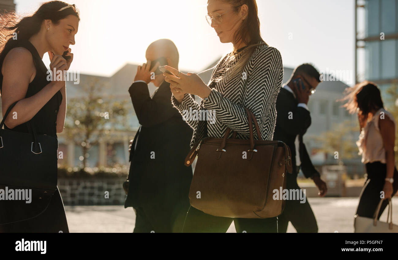 Men and women using mobile phone while commuting to office on a crowded ...