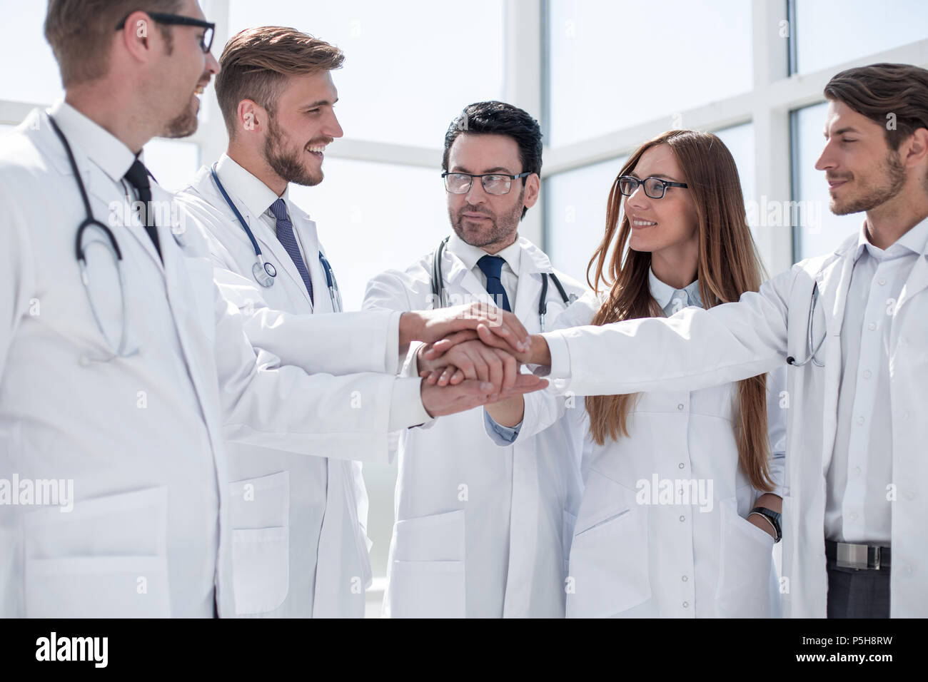 group of doctors with their hands folded together Stock Photo - Alamy