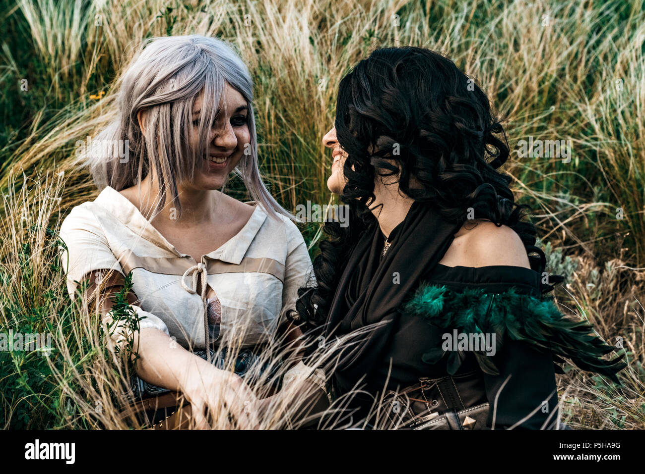 Fantasy cosplay two beautiful sit together in grass Stock Photo - Alamy