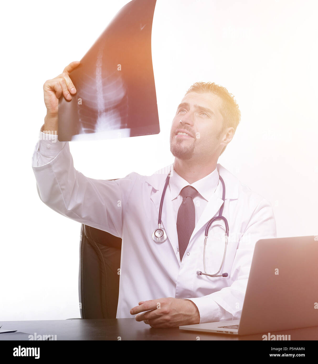 doctor examines an x-ray,sitting behind a Desk Stock Photo - Alamy
