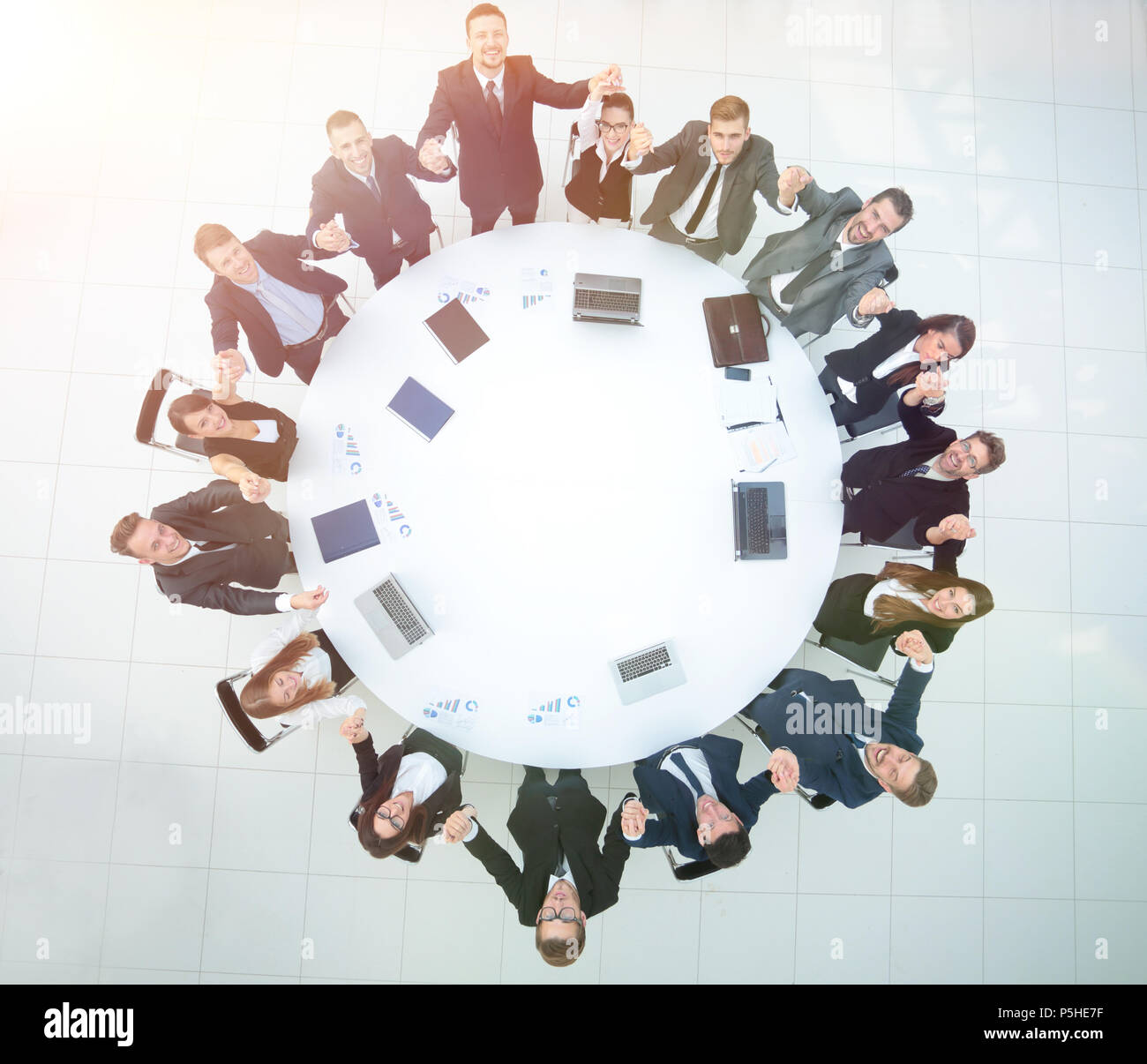 large business team sitting at the round table and raising his hands up ...