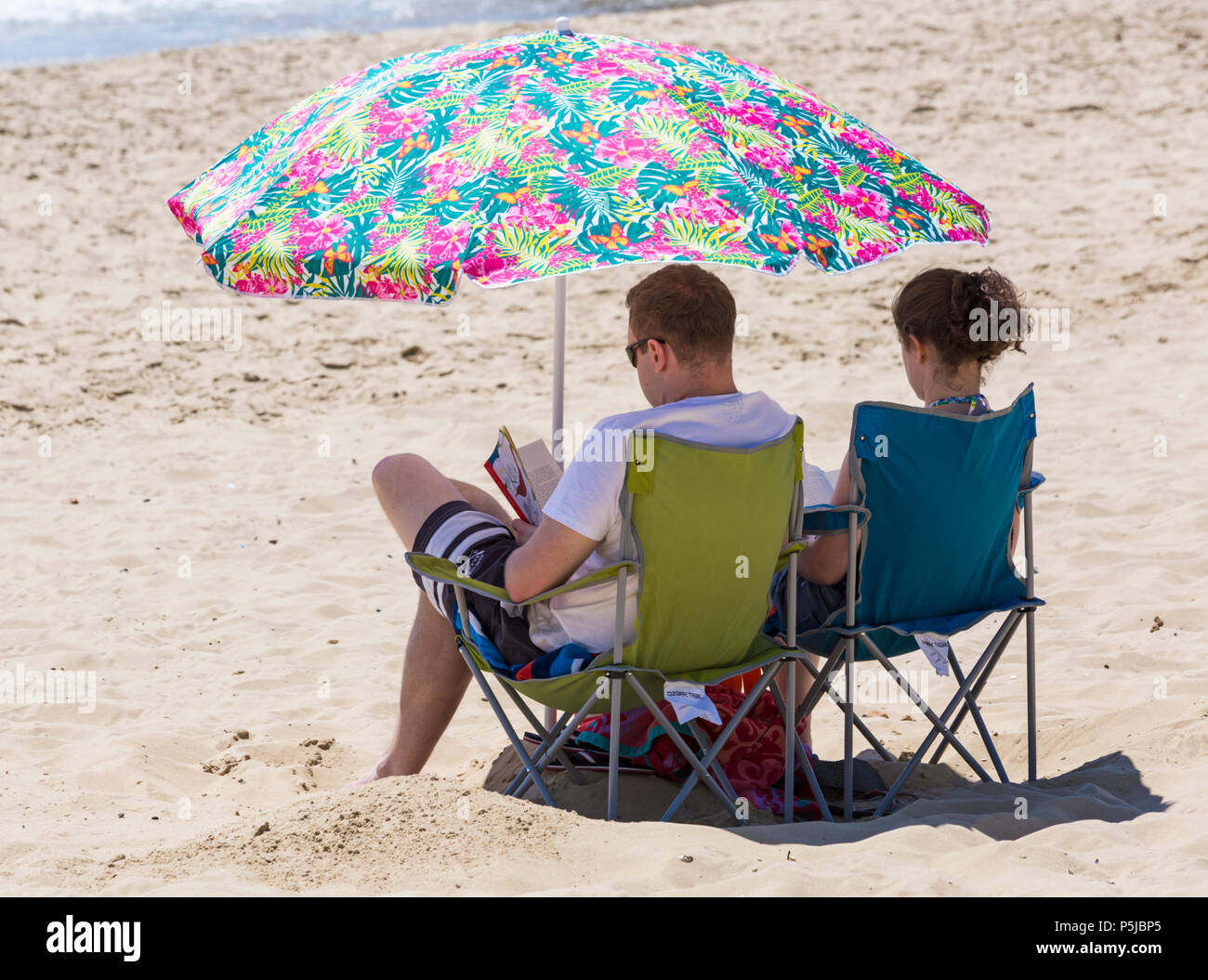 Women under a beach umbrella hi-res stock photography and images - Alamy