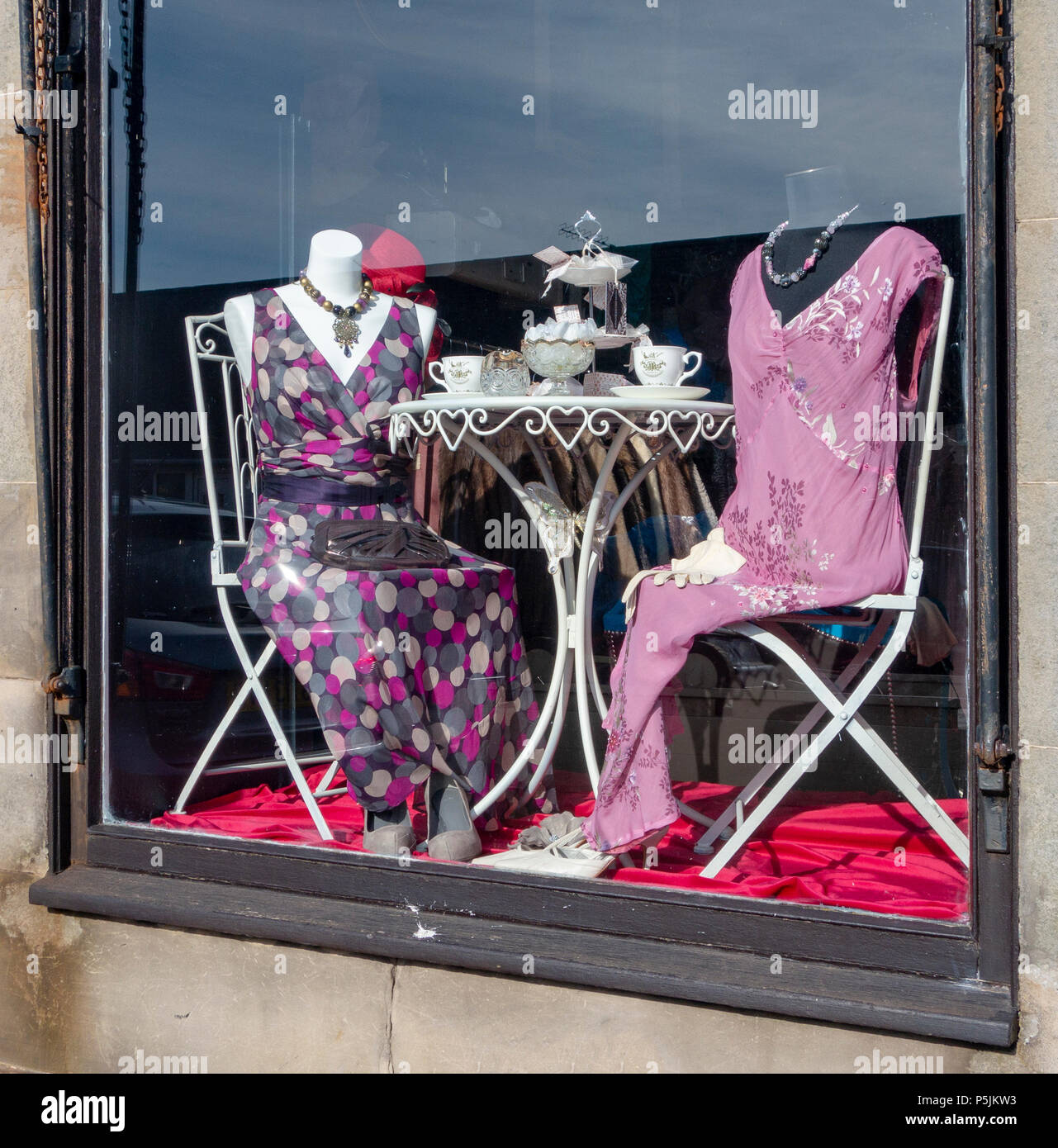 Headless female dummies sitting at a table in a shop window Stock Photo ...
