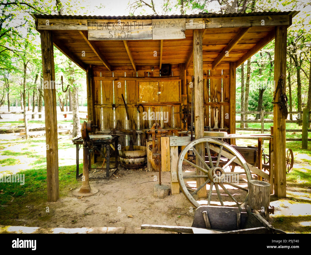 Old country blacksmith shed with horseshoes, wagon wheels, anvil, and ...