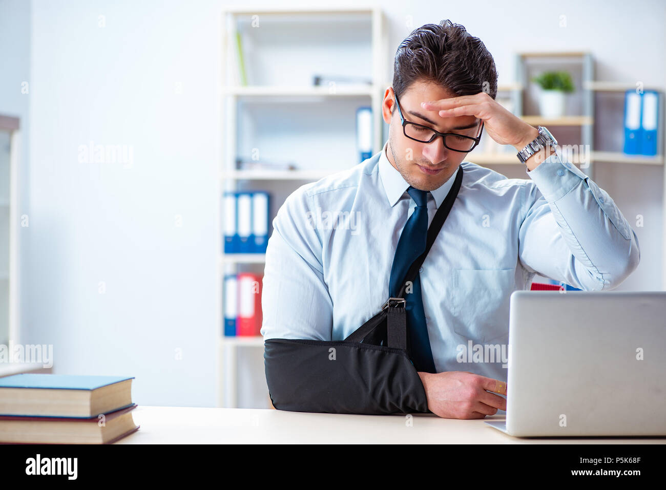 Businessman with broken arm working in office Stock Photo - Alamy