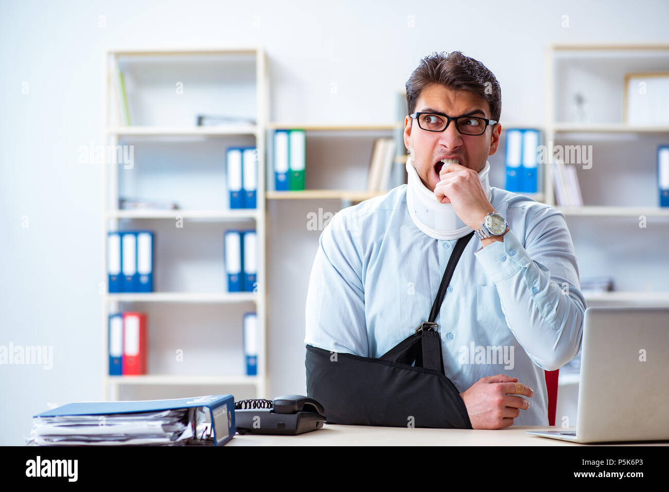 Businessman with broken arm working in office Stock Photo - Alamy