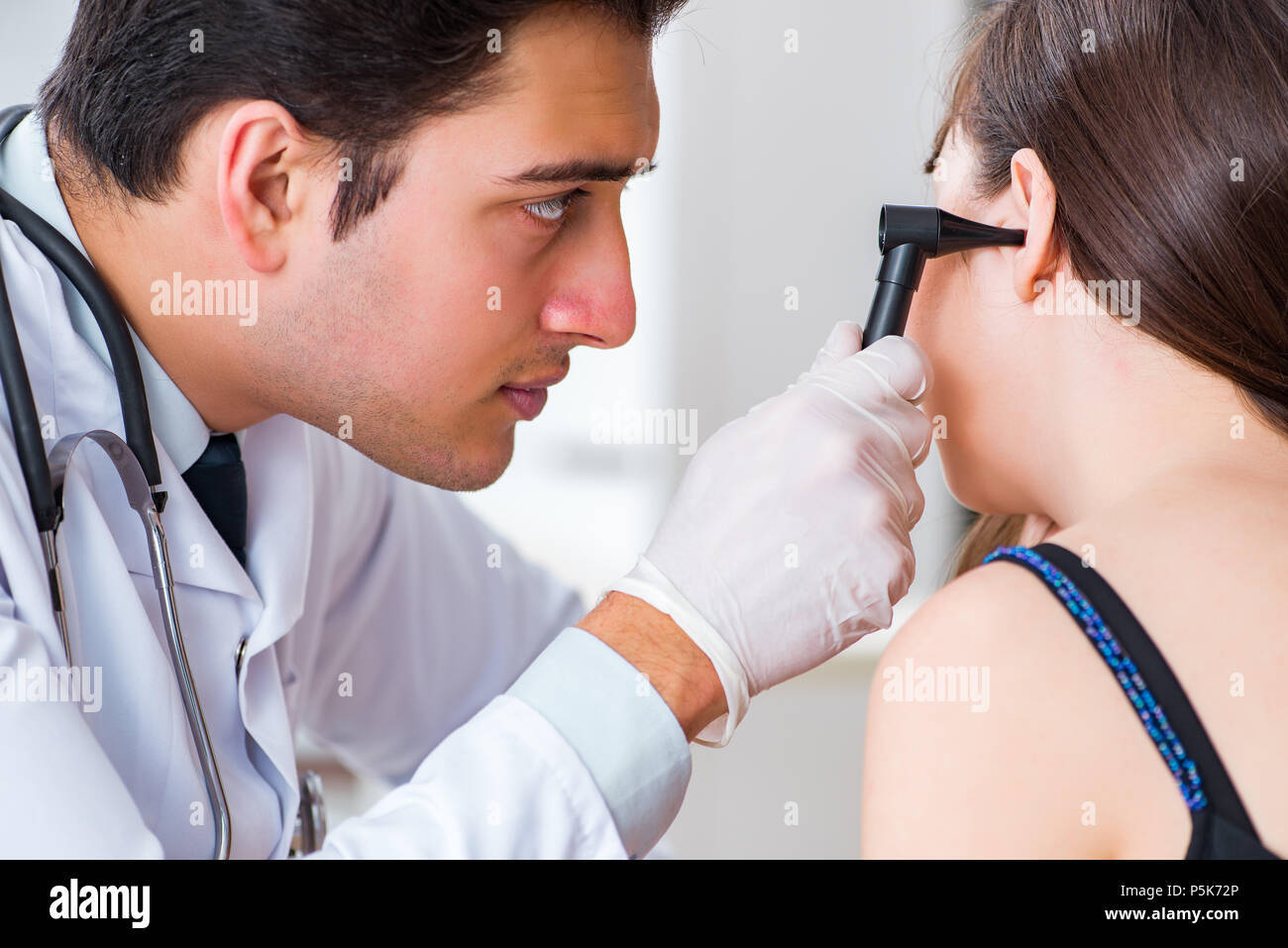 Doctor checking patients ear during medical examination Stock Photo - Alamy