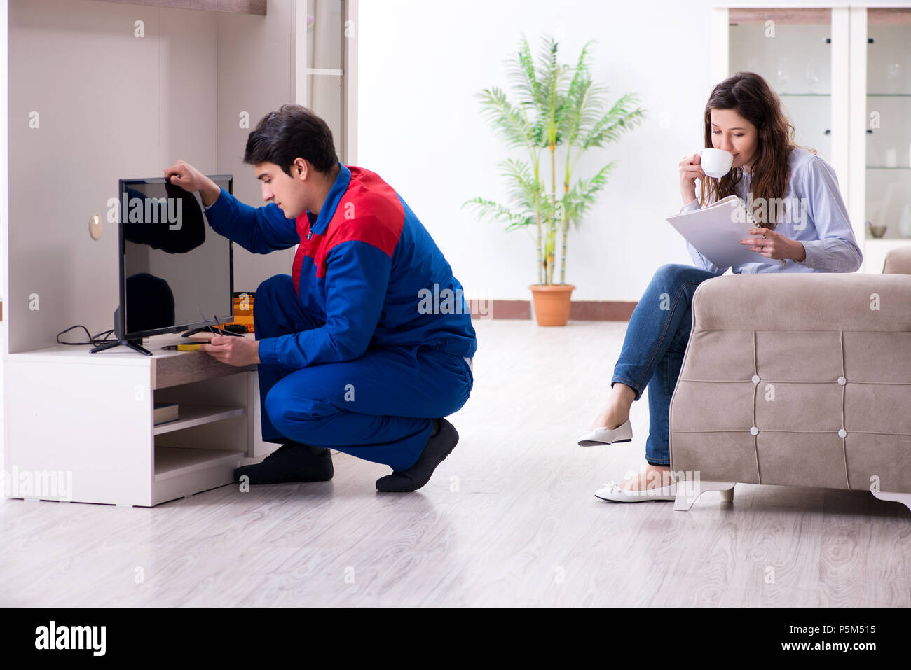 Tv repairman technician repairing tv at home Stock Photo - Alamy