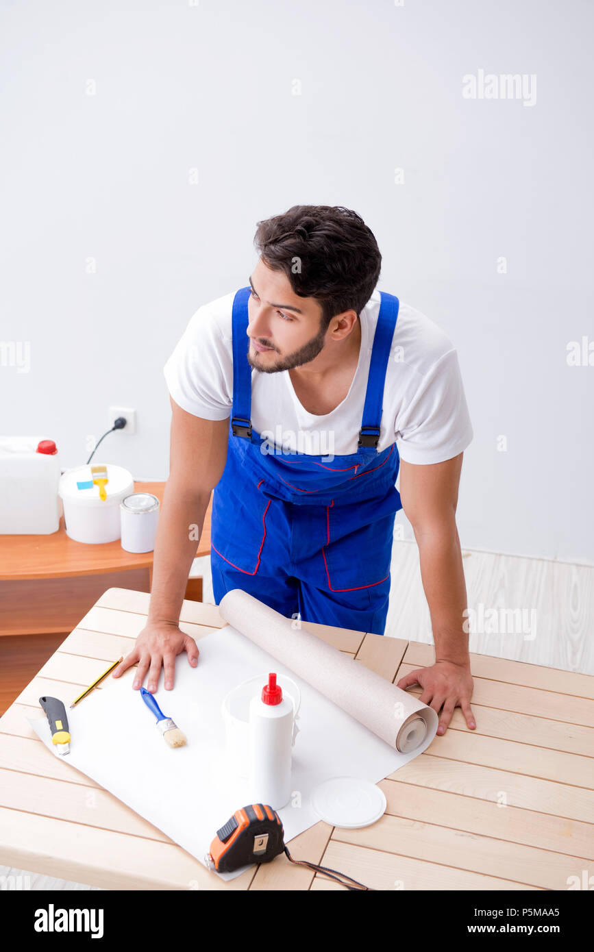 Worker working on wallpaper during refurbishment Stock Photo - Alamy
