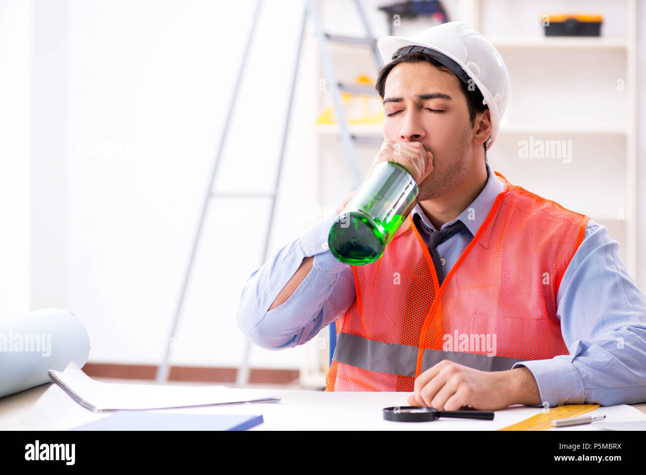 Drunk engineer working in the workshop Stock Photo - Alamy