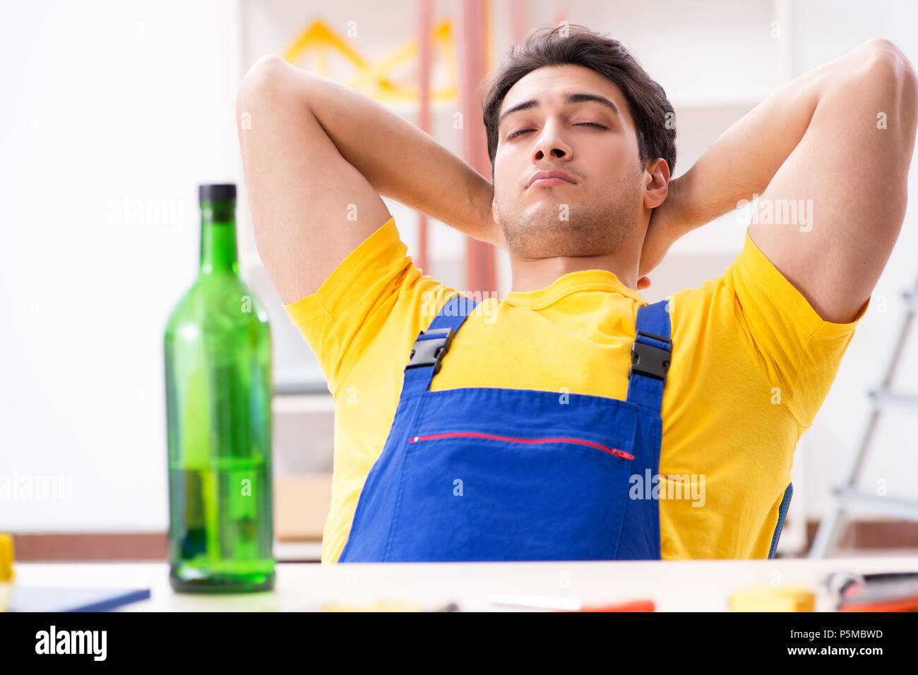 Drunk engineer working in the workshop Stock Photo - Alamy