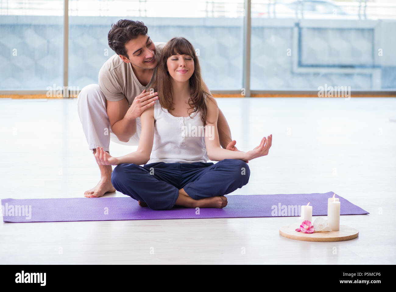 Personal coach helping during yoga session Stock Photo - Alamy