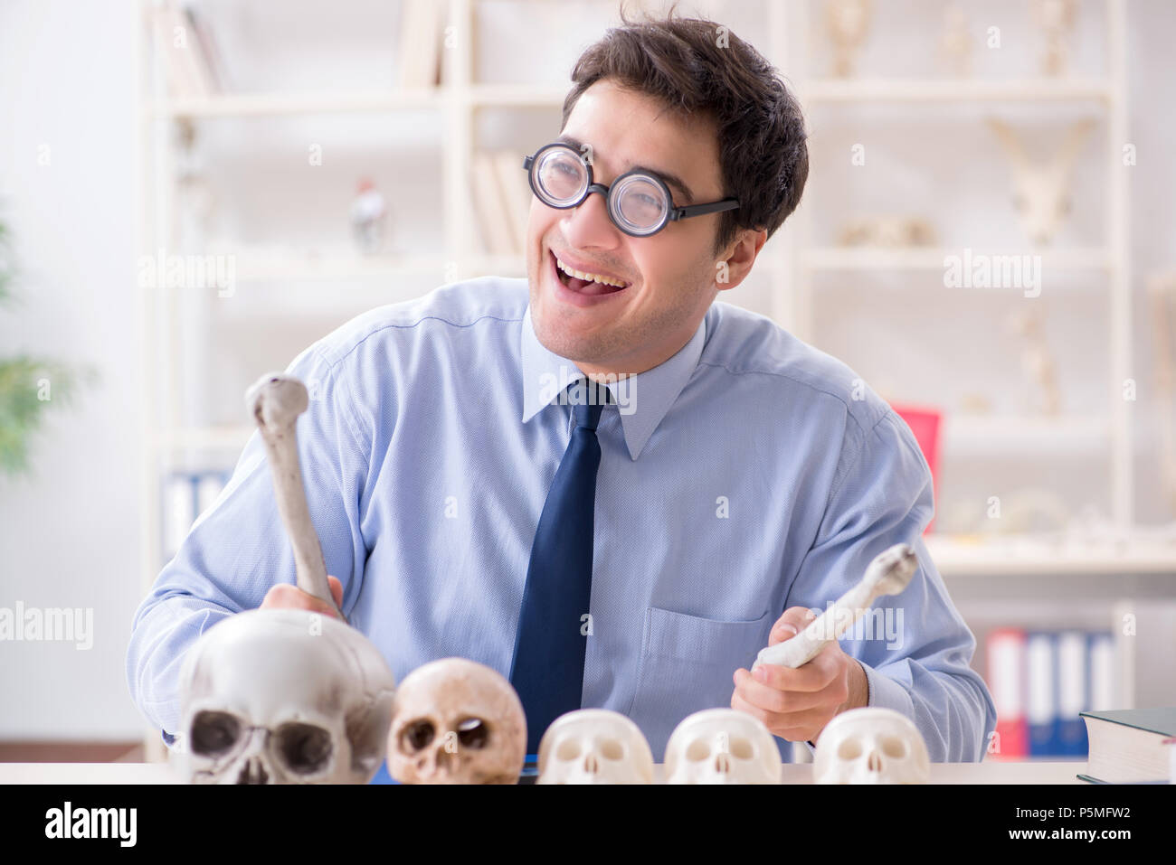 Funny crazy professor studying human skeleton Stock Photo - Alamy