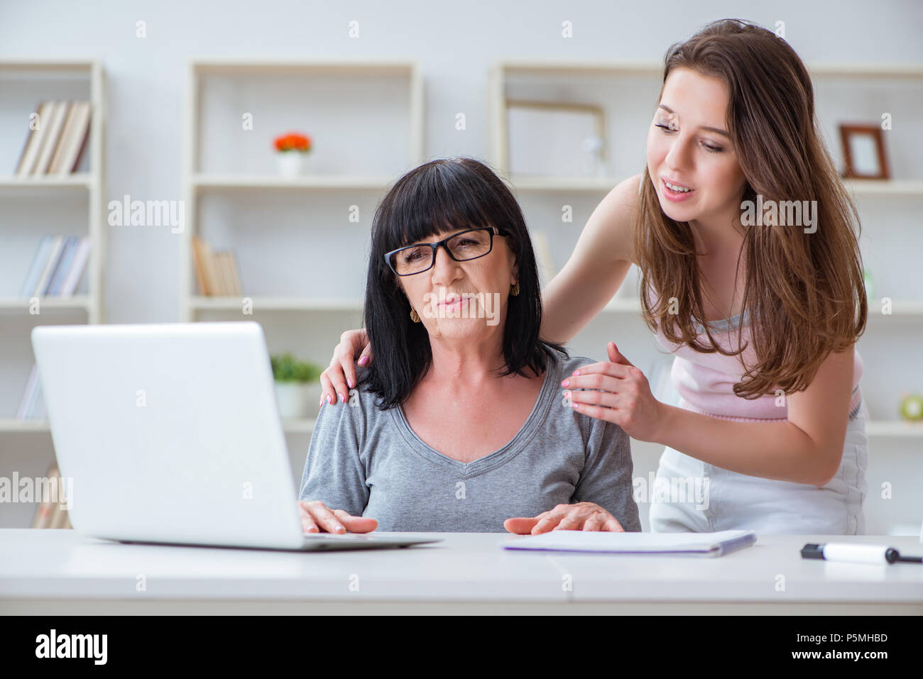 Daughter explaining to mom how to use computer Stock Photo - Alamy