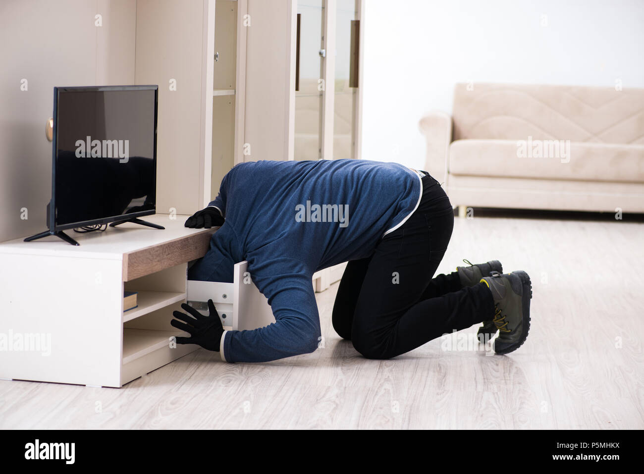 Man burglar stealing tv set from house Stock Photo - Alamy