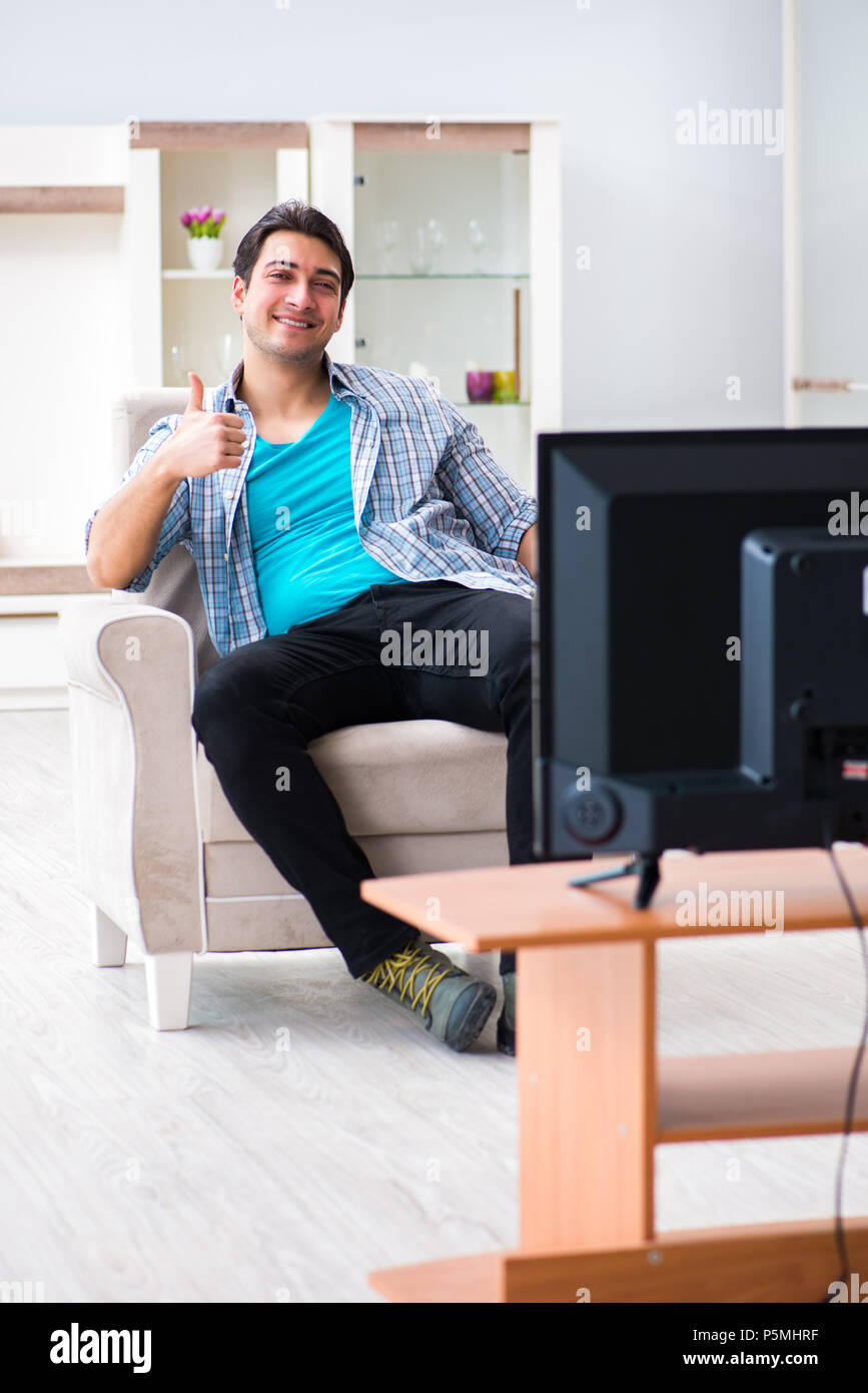 Man watching tv at home Stock Photo - Alamy