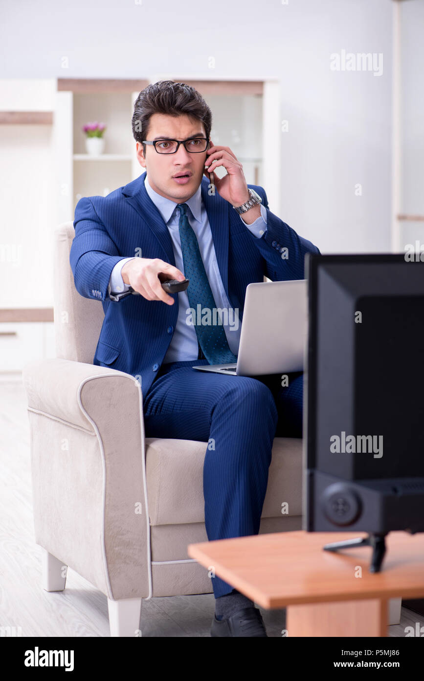 Businessman watching tv in the office Stock Photo - Alamy