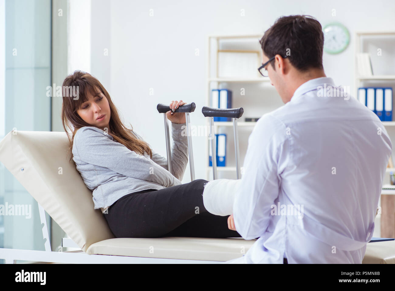 Doctor examining patient with broken leg Stock Photo - Alamy