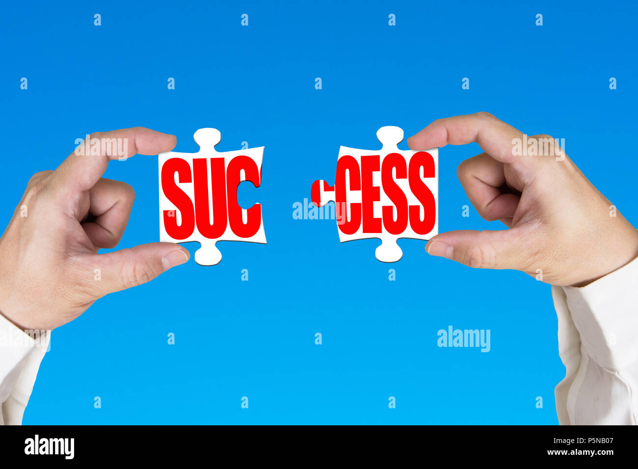 Linking two puzzles for success in blue background Stock Photo - Alamy