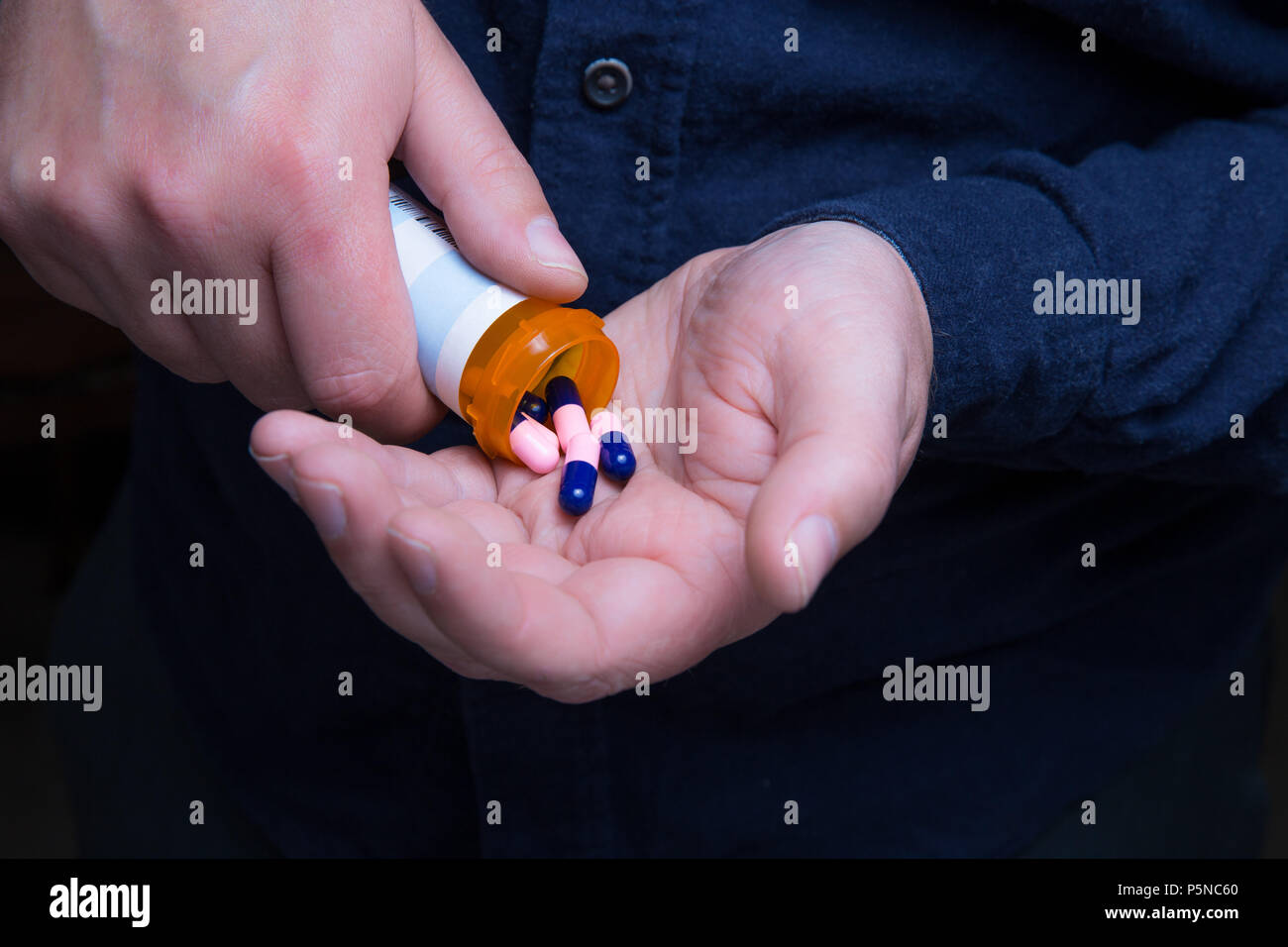 Pouring pills into palm from pill bottle Stock Photo - Alamy