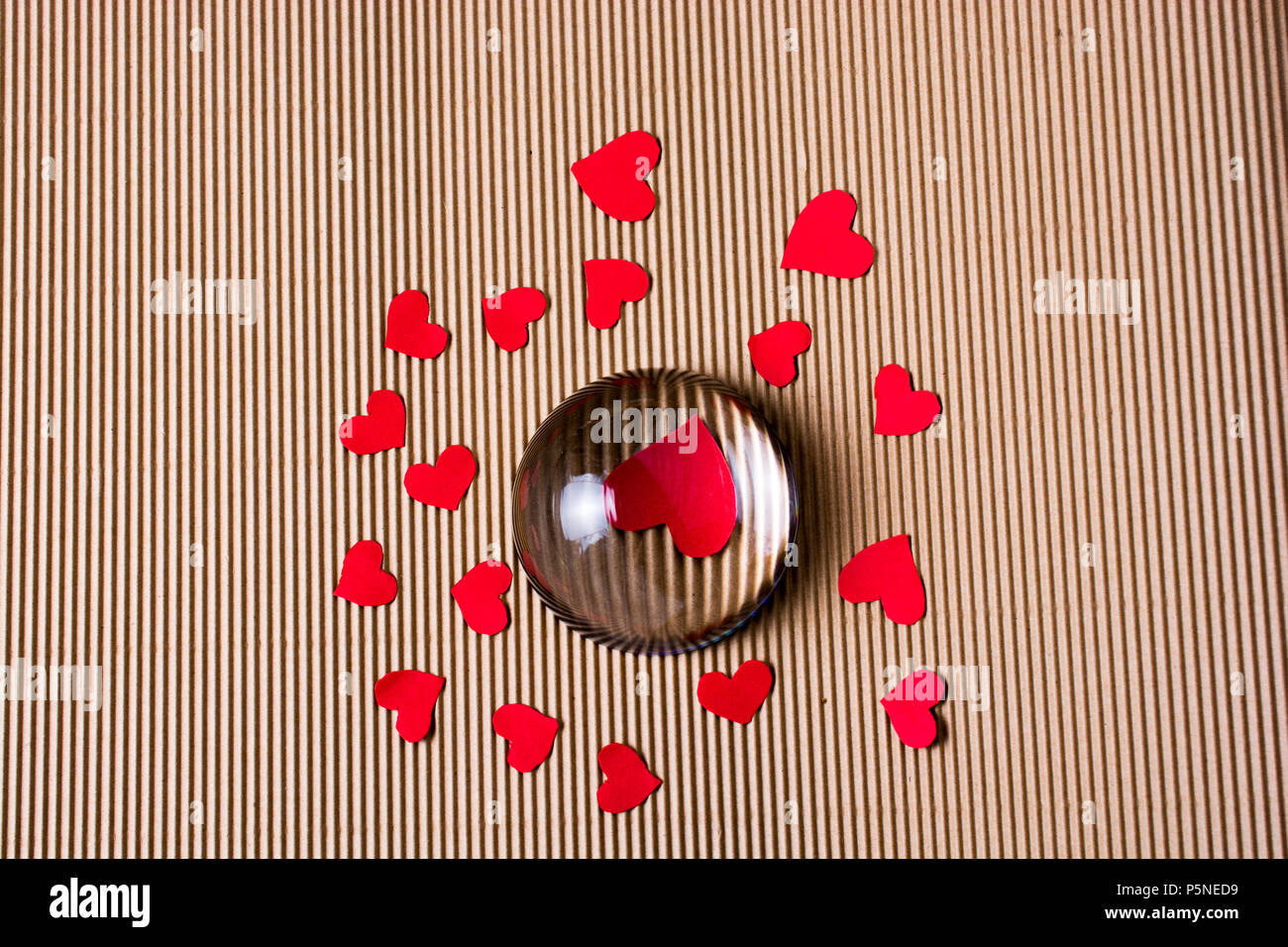 Red color paper hearts under and around half glass globe Stock Photo ...