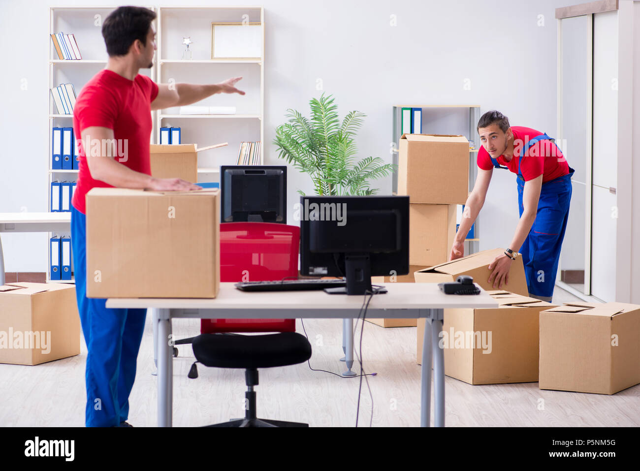 Two contractor employees moving personal belongings Stock Photo - Alamy