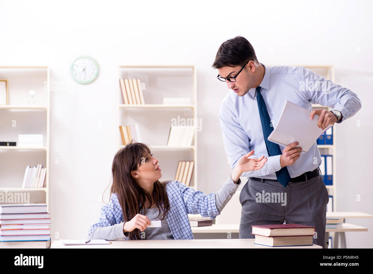 Male lecturer giving lecture to female student Stock Photo - Alamy
