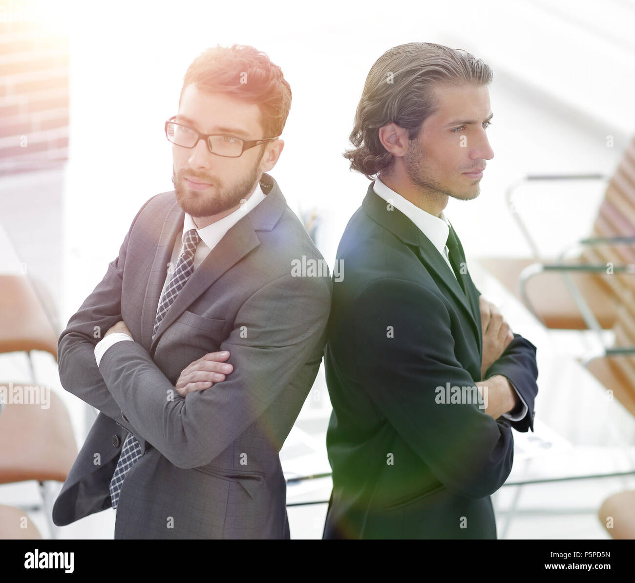 Two men standing back to back and support each other Stock Photo - Alamy