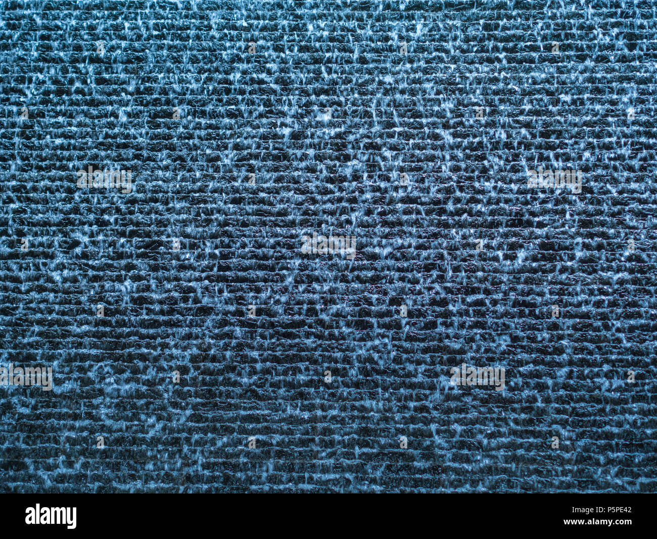 Modern fountain - water running down a stone wall Stock Photo - Alamy