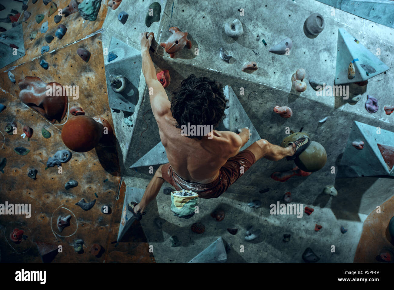 Free climber young man climbing artificial boulder indoors Stock Photo ...