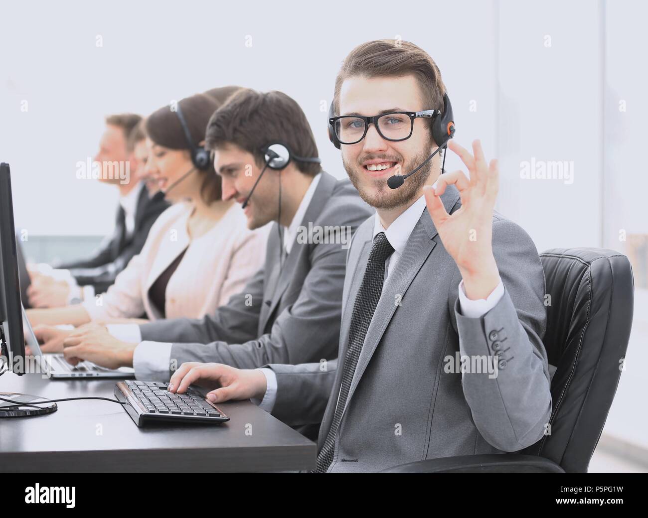 customer service representative with headset showing sign "OK Stock ...