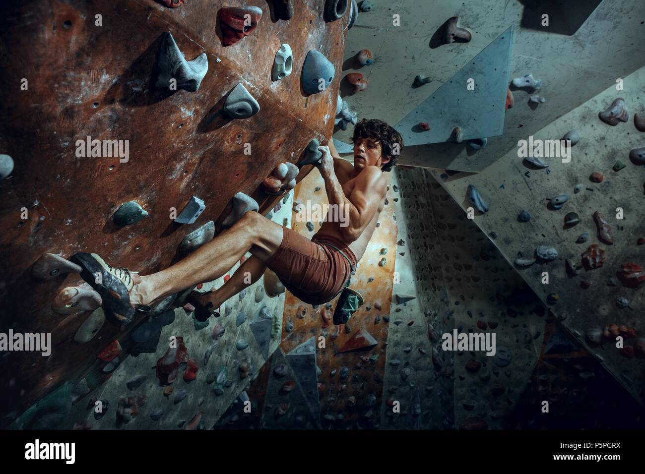Free climber young man climbing artificial boulder indoors Stock Photo ...