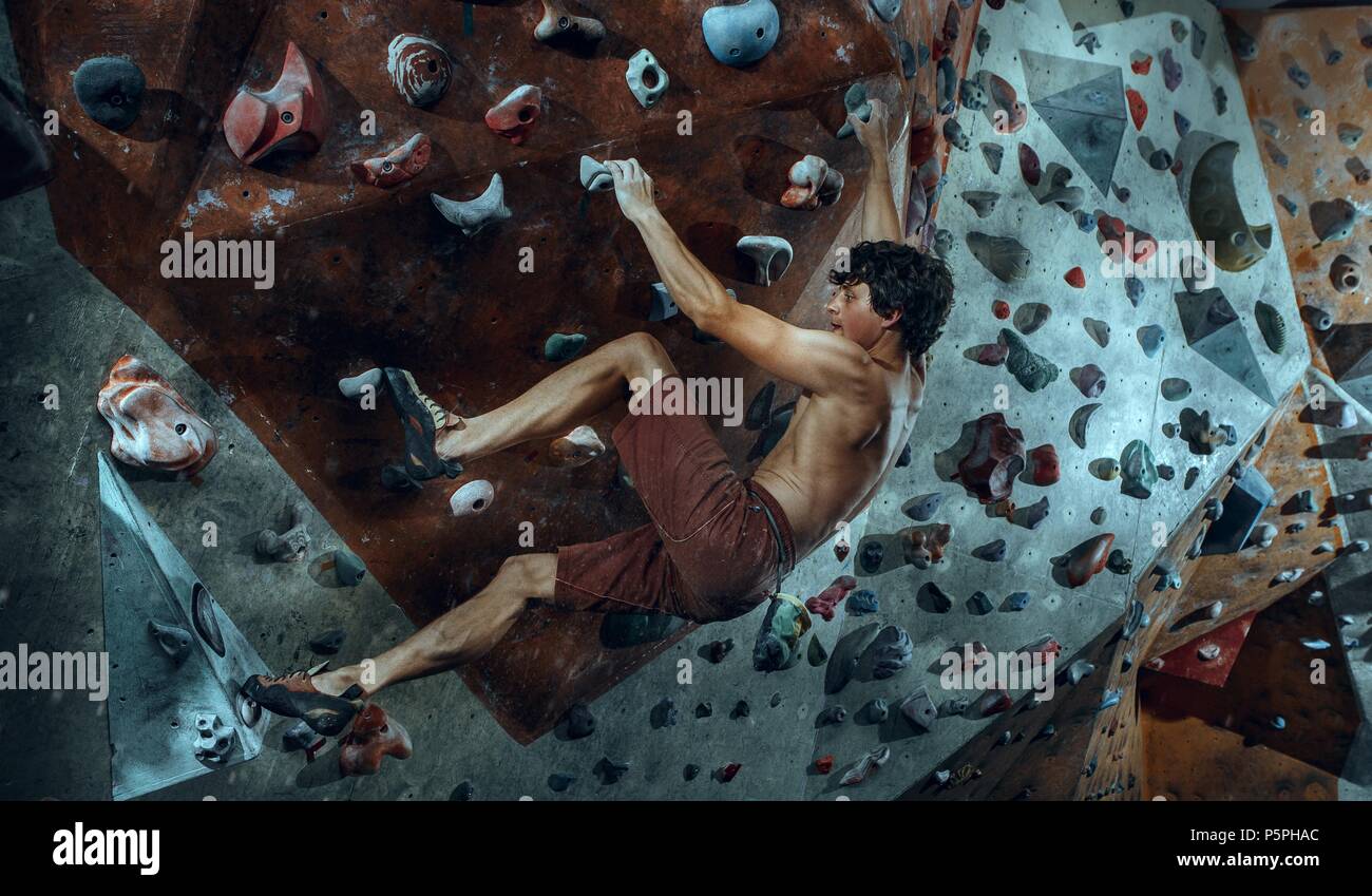 Free climber young man climbing artificial boulder indoors Stock Photo ...