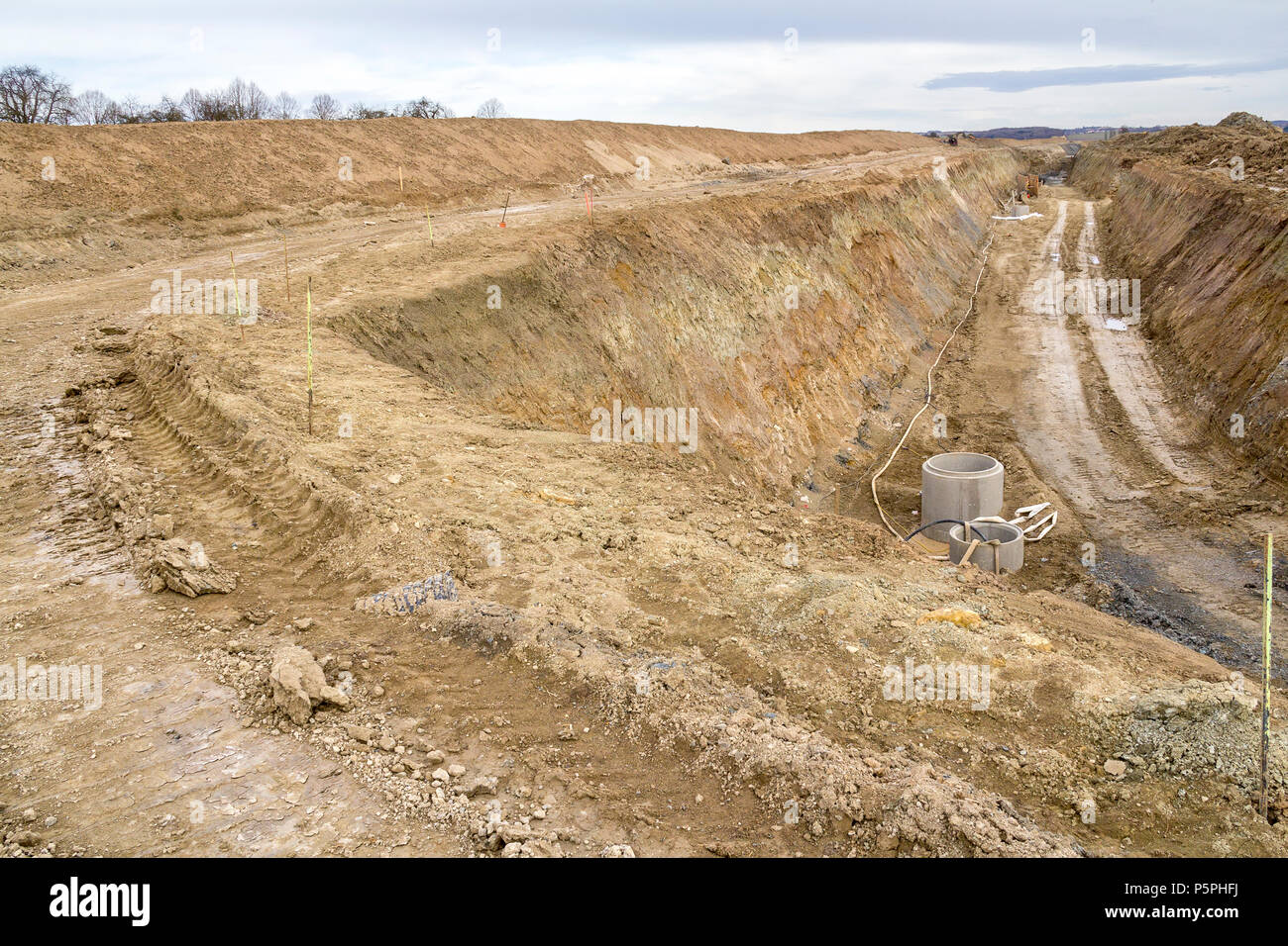 construction site including a big trench with lots of earth and loam ...