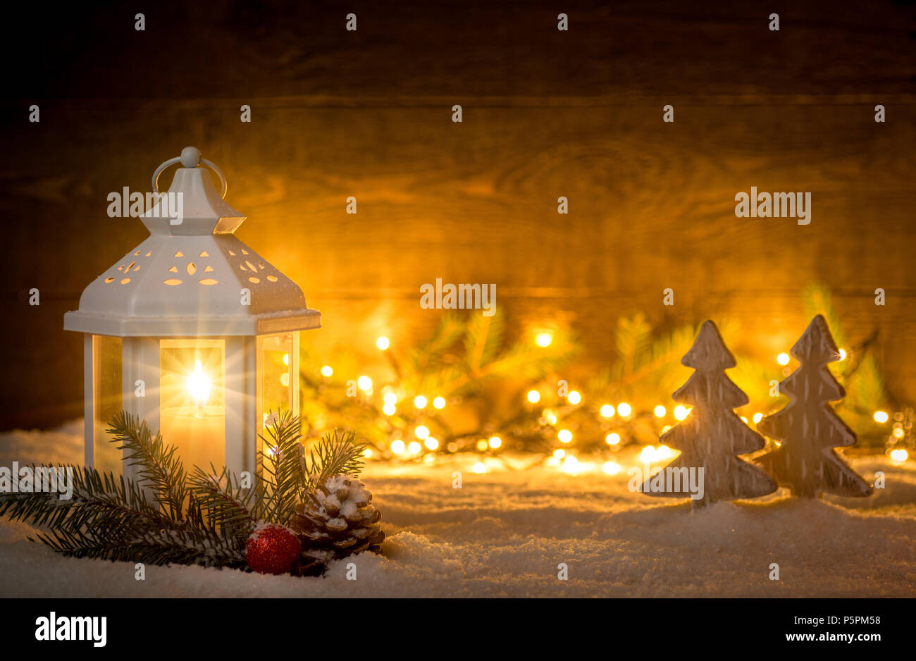 Christmas scene with a lantern, trees, fir branch and blurred lights in ...