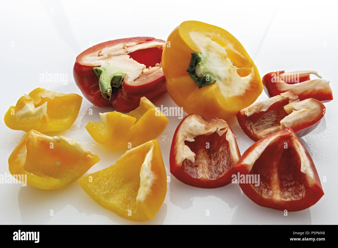 yellow and red pepper in half and pieces on white background Stock ...