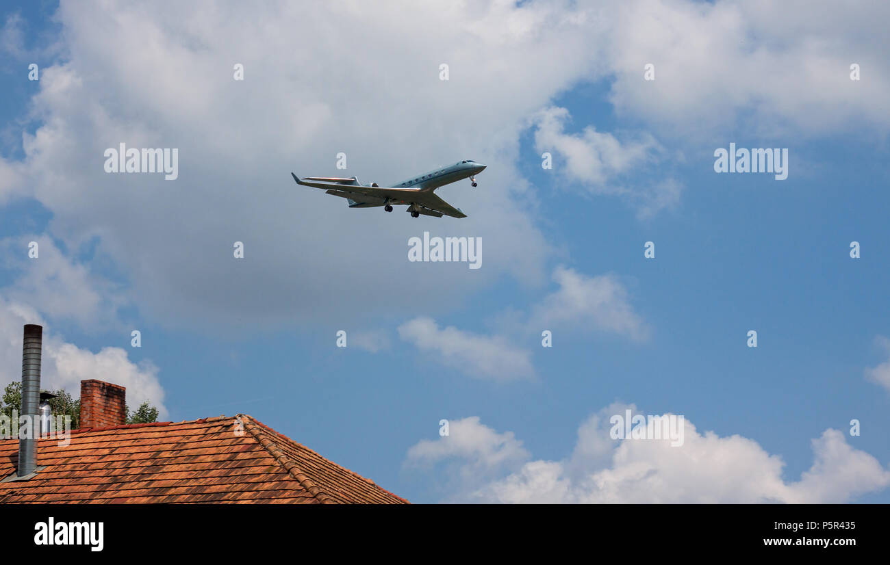 Jet passenger airplane flying above roof approaching for landing Stock ...