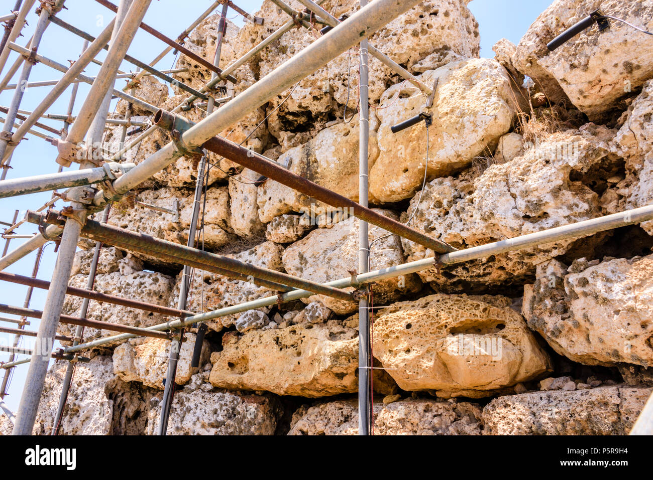 Scaffold poles hold up a wall of the ancient megalithic temple of ...