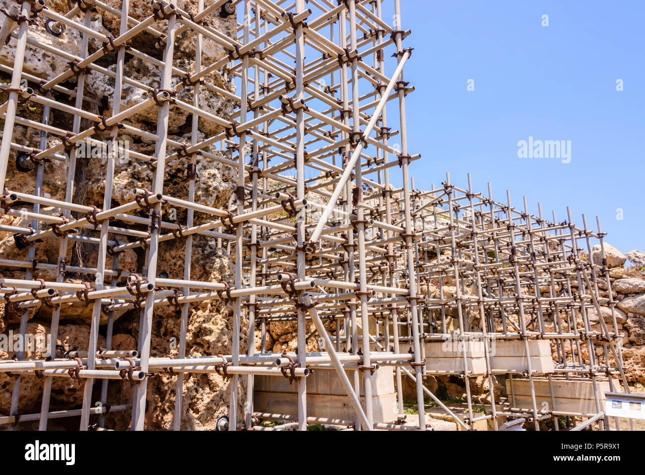 Scaffold poles hold up a wall of the ancient megalithic temple of ...