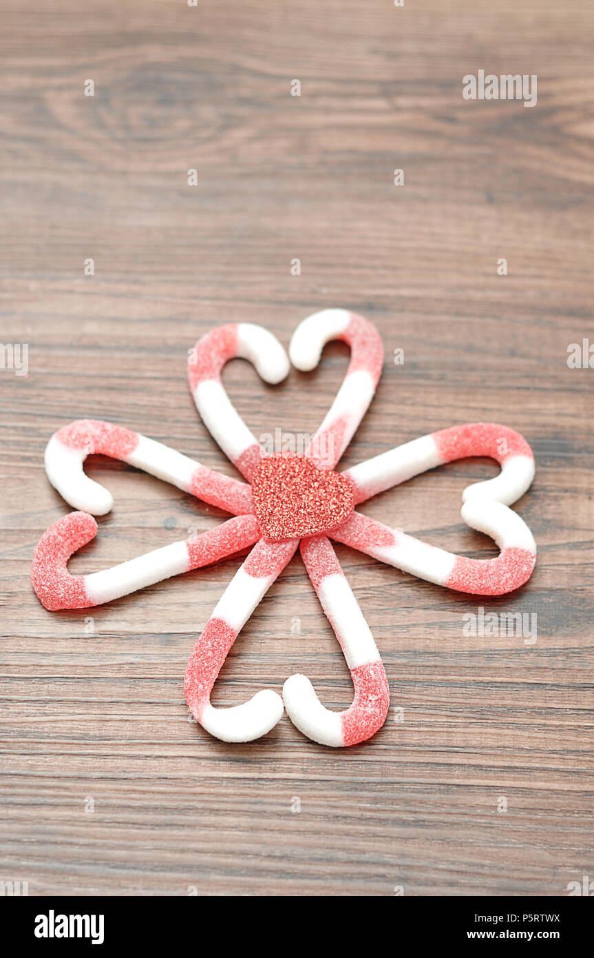 A flower pattern made out of candy canes packed in heart shapes with a ...