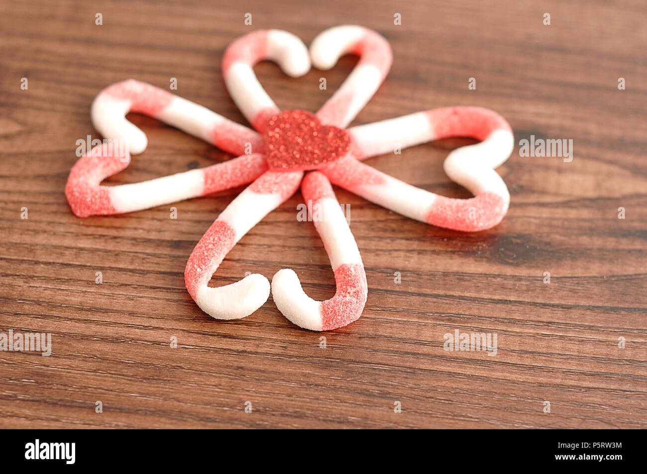A flower pattern made out of candy canes packed in heart shapes with a ...