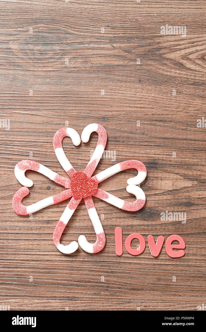 A flower pattern made out of candy canes packed in heart shapes with a ...
