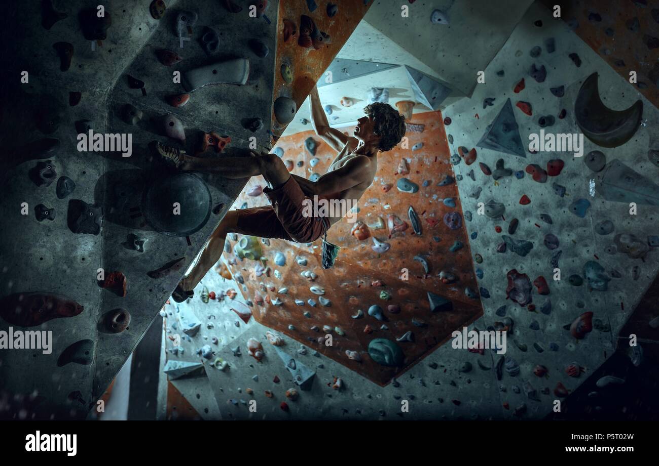 Free climber young man climbing artificial boulder indoors Stock Photo ...