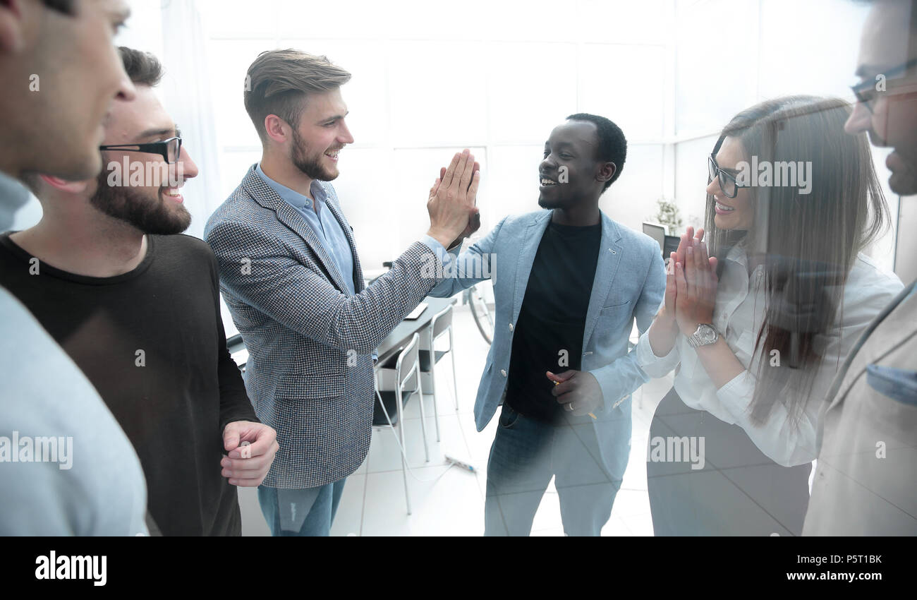 happy colleagues giving each other a high five Stock Photo - Alamy