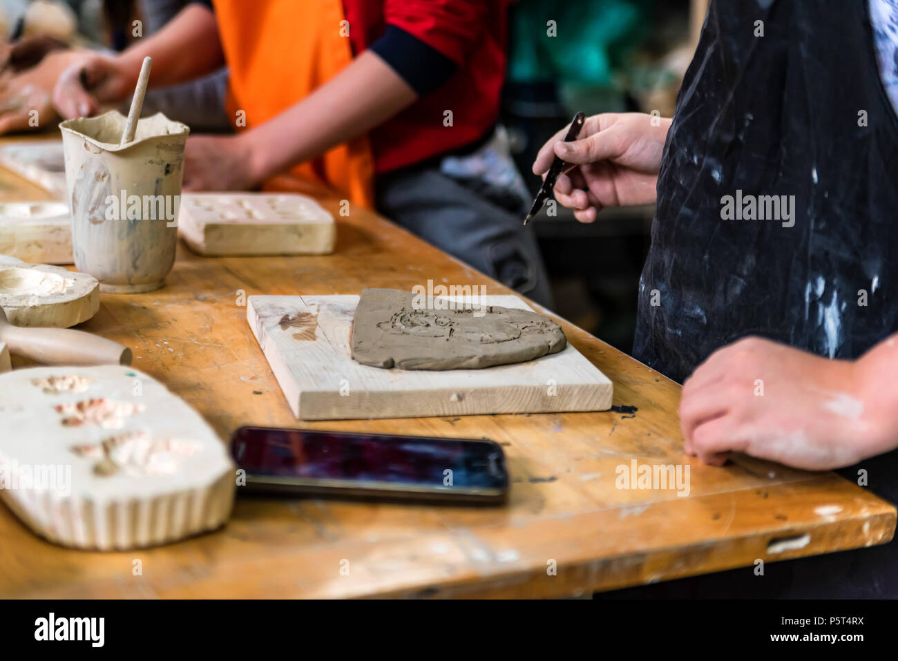 Pottery workshop. hands make print on clay Stock Photo - Alamy