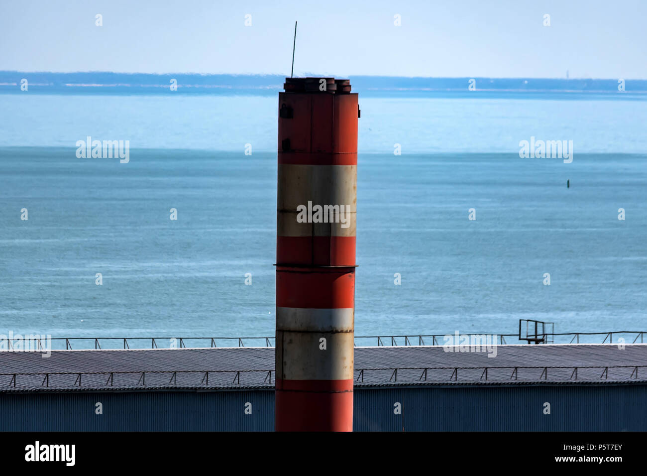 Industrial sea port with tall pipe Stock Photo - Alamy