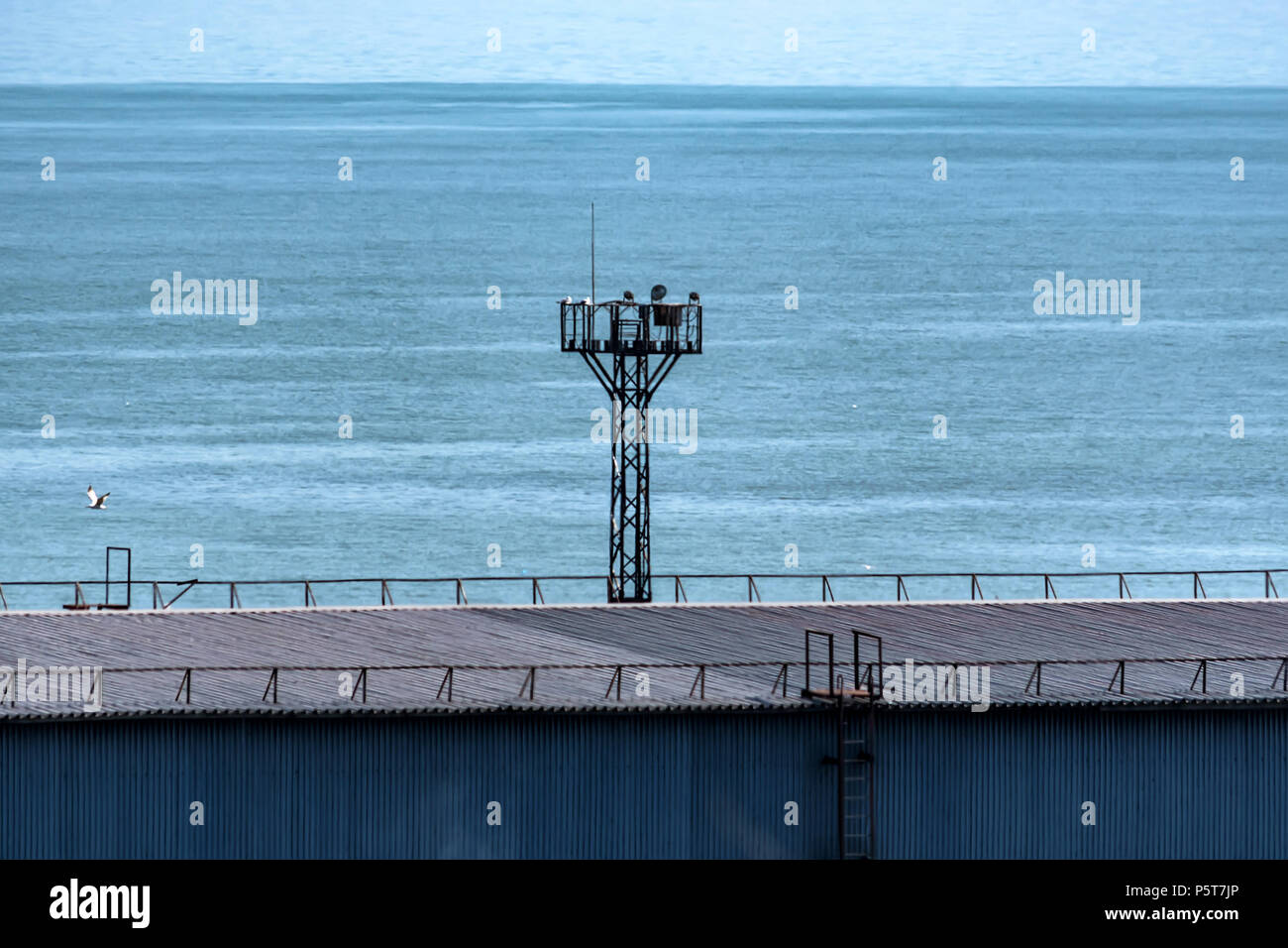 Industrial sea port with tall electric tower Stock Photo - Alamy