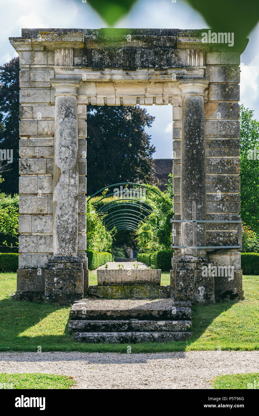 Ancient columns in the park, an ancient stone arch covered with moss ...