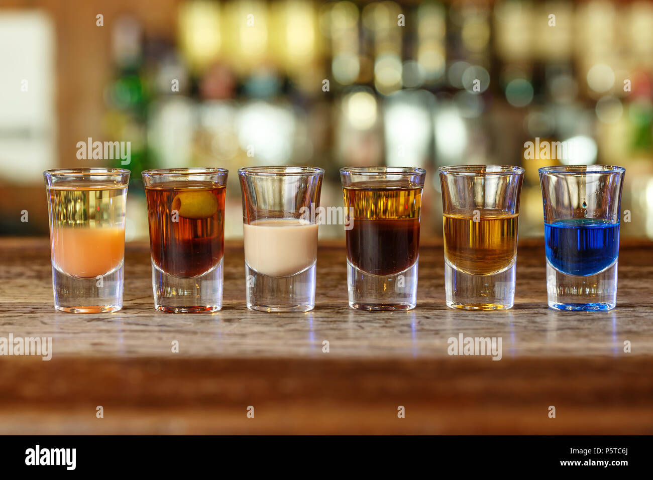 Multi-colored alcoholic cocktails on the bar, a night club party, space ...