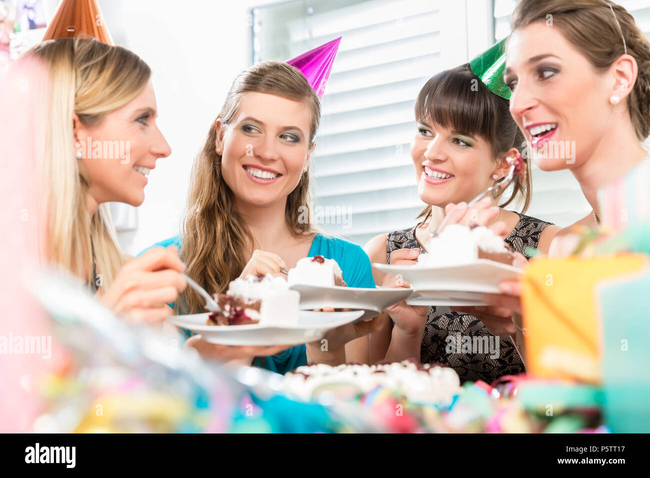 Beautiful female best friends sharing a birthday cake Stock Photo - Alamy